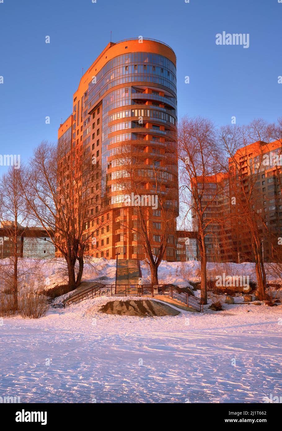A new house on the river bank. Multi-storey new building on the snowy ...