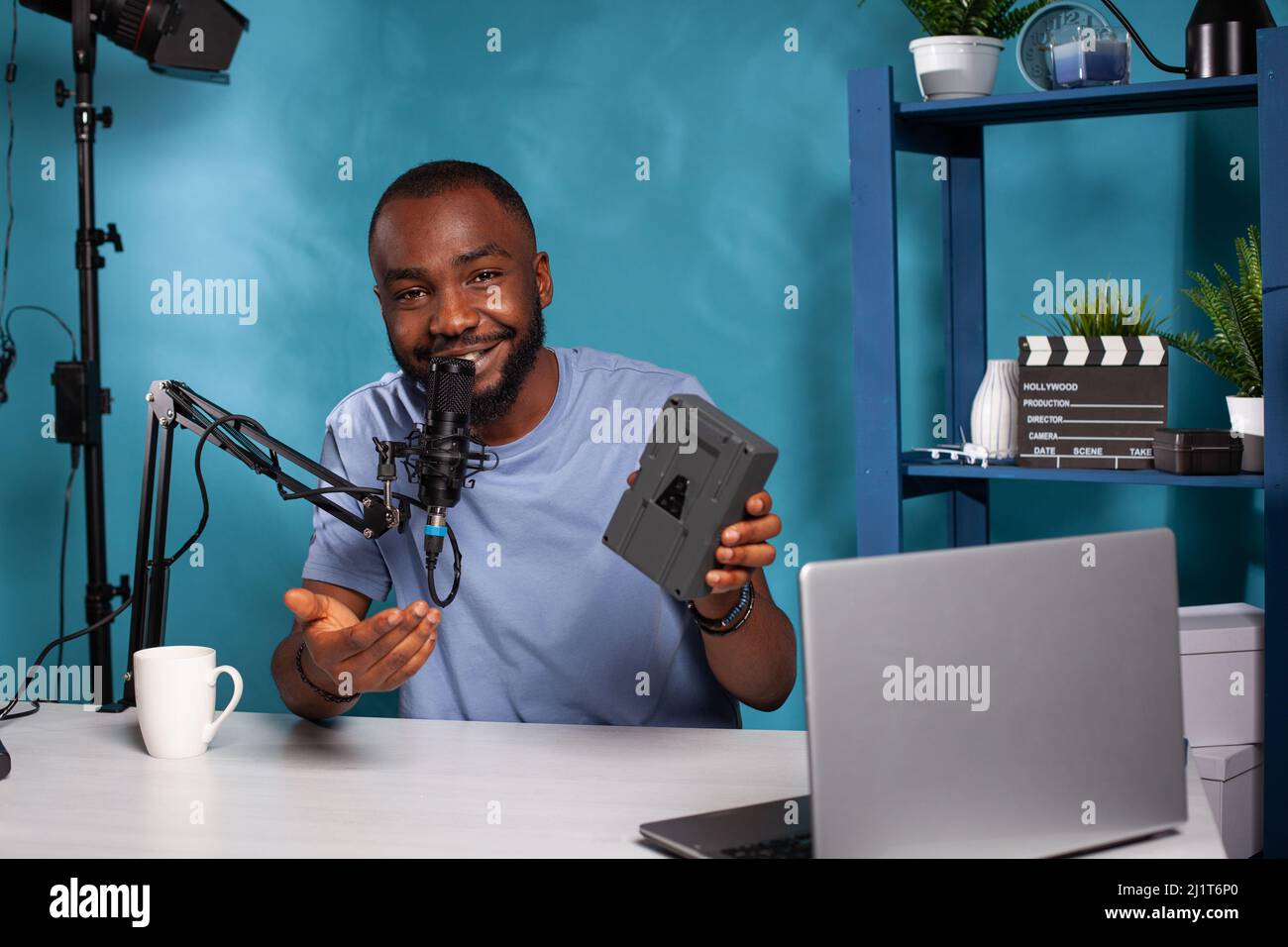 Vlogger reviewing v mount rechargeable battery product features sitting ...