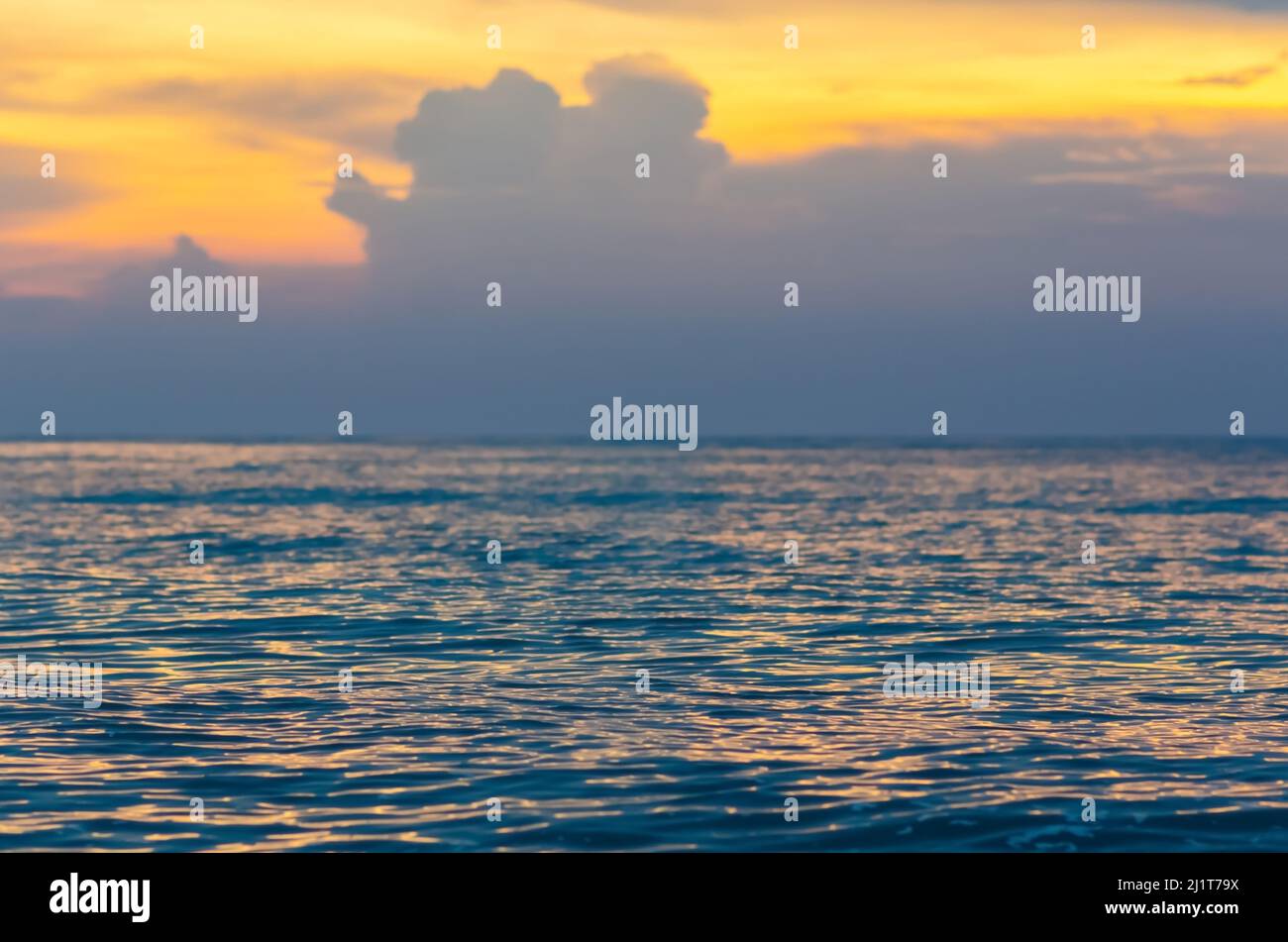 Partial focus of the sea that have sun light reflection with yellow sky ...