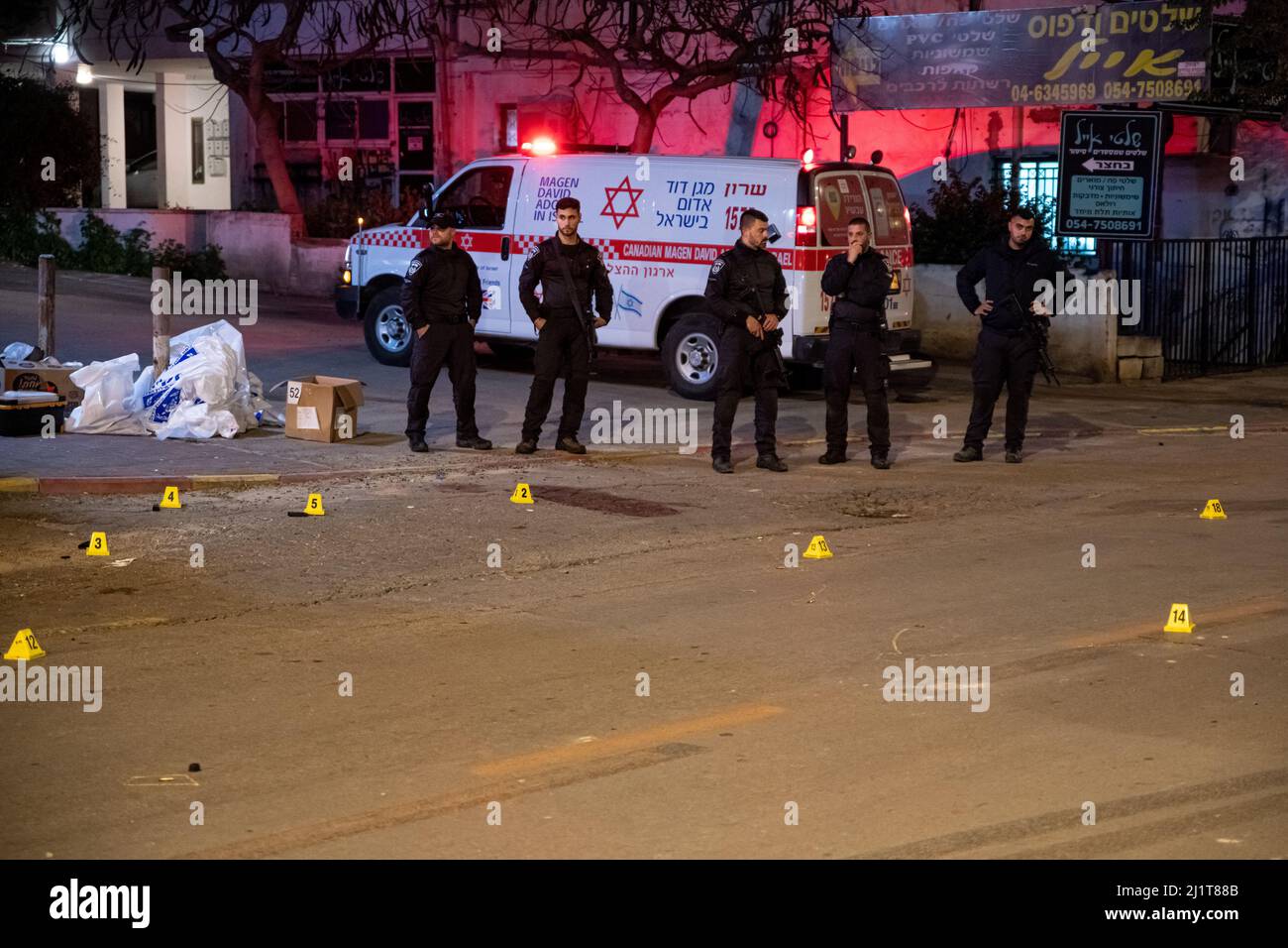 Israel. 27th Mar, 2022. Policeman next to a victim's blood on the road ...