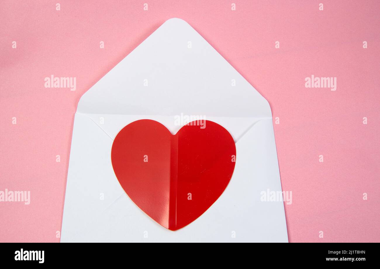 Close-up photo of an open white envelope and a red greeting card in the ...