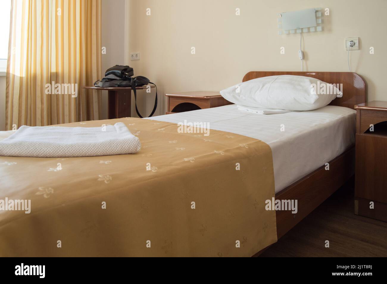 Hotel single Room with a bed, an armchair and a table with men's black ...