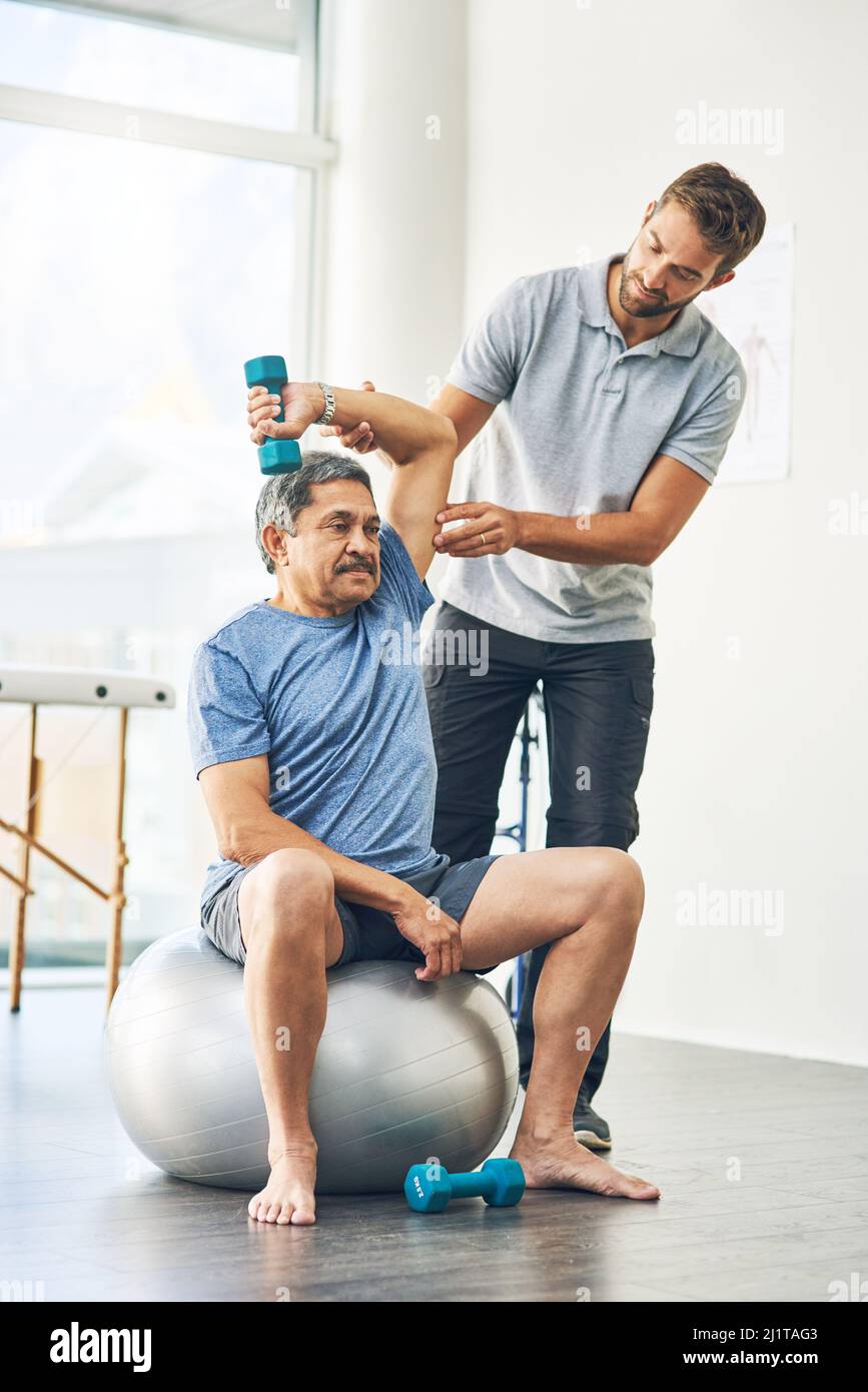 Any discomfort at all. Full length shot of a young male physiotherapist ...