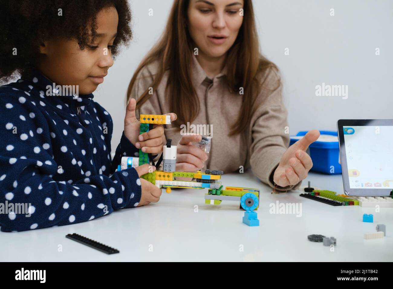Multiethnic kids at STEM lesson constructing robot in classroom with ...