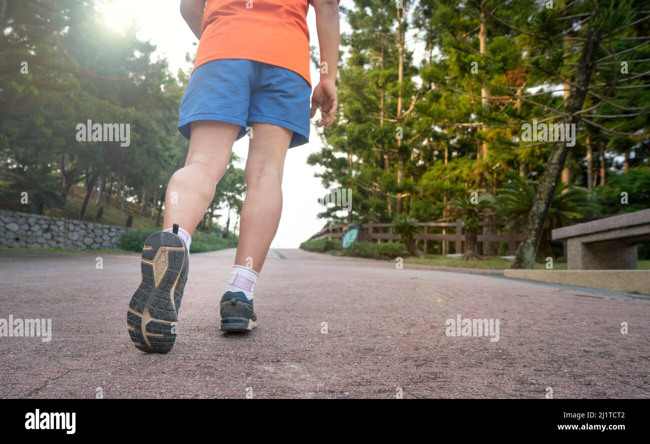 Man runner jogging down an outdoor path during sunset. Copy space Stock ...