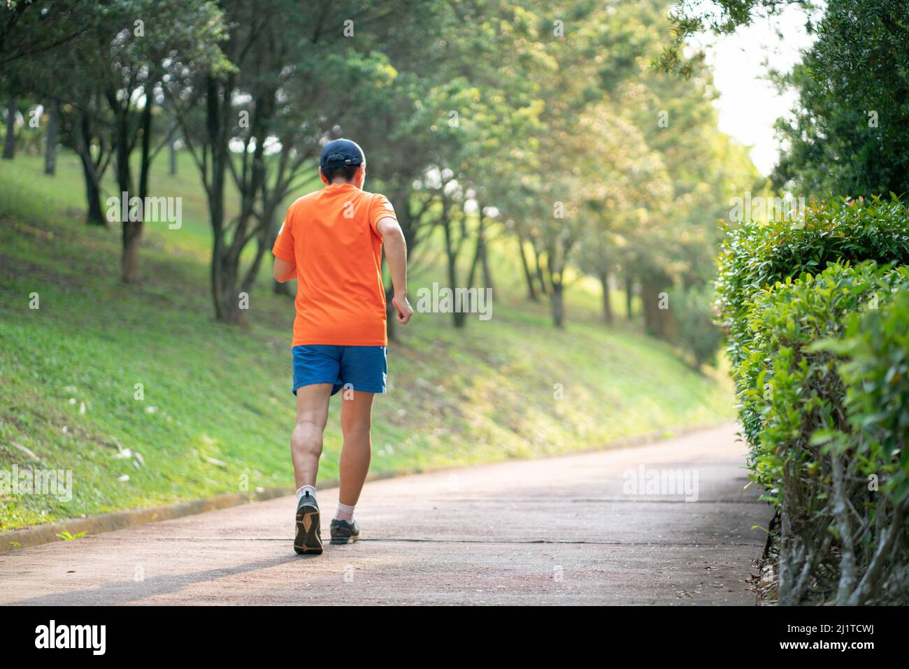 Man runner jogging on an outdoor path during sunset. Healthy lifestyle ...