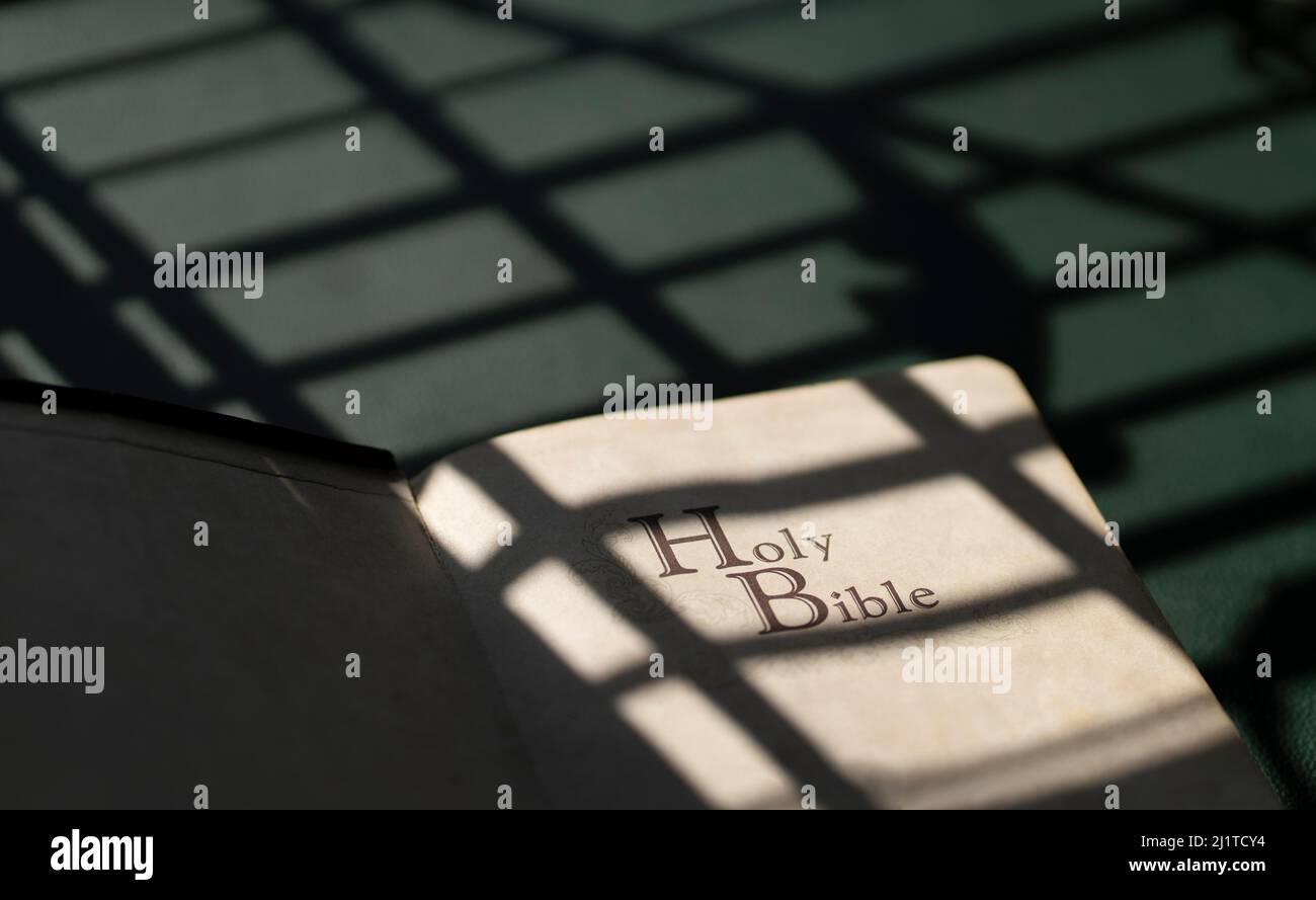 Open Holy Bible on table, with shadow on page. Copy space Stock Photo ...