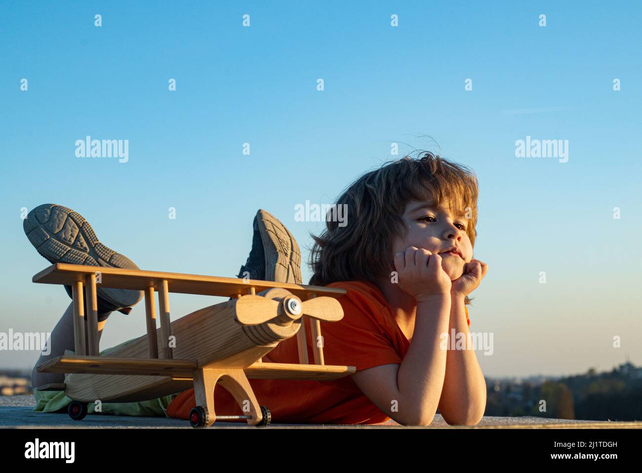 Kid 6 year old dreaming and plays with a toy plane in the park. Dreams ...