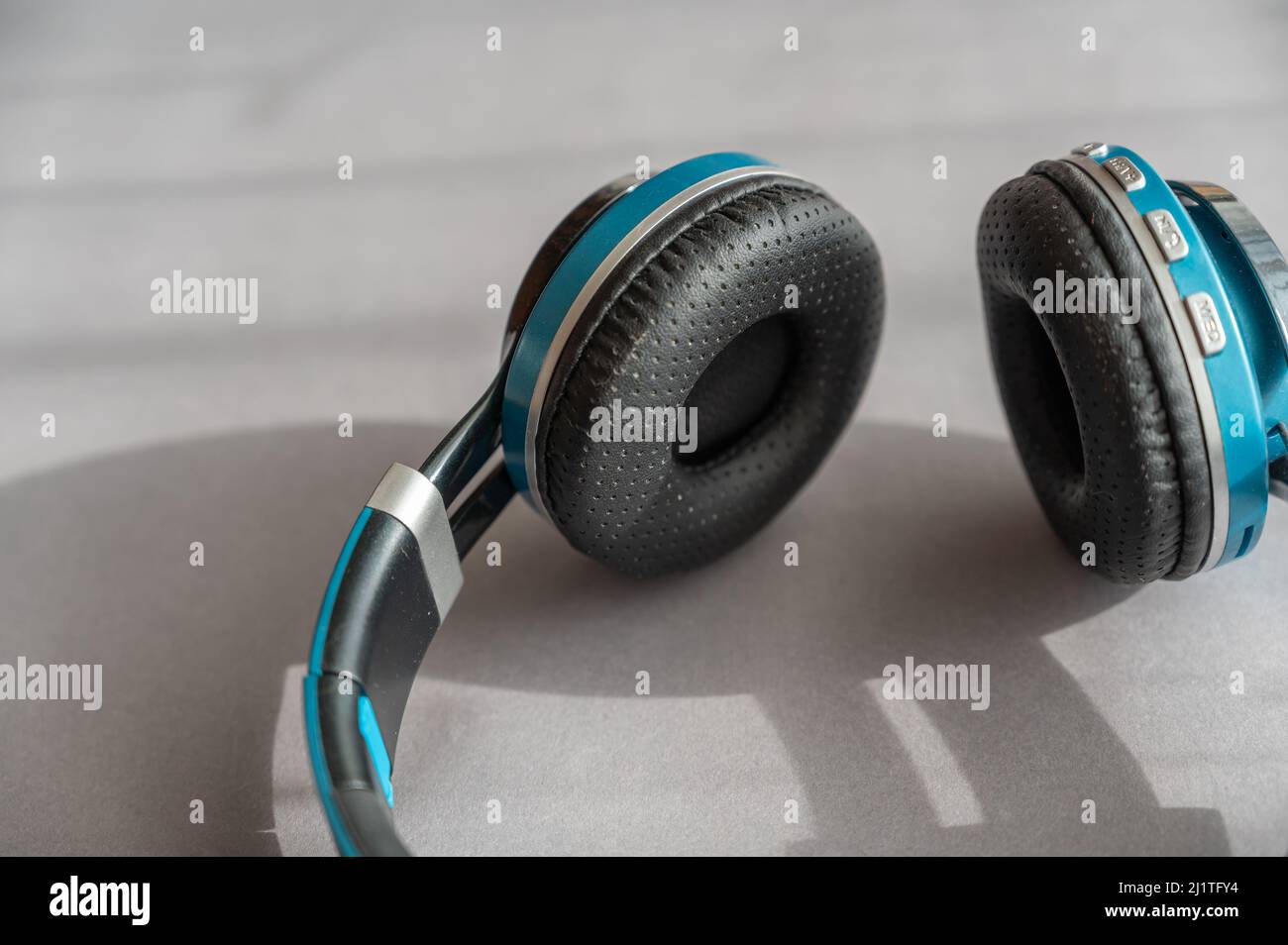 Turquoise and black headphones against a gray background. Wireless ...