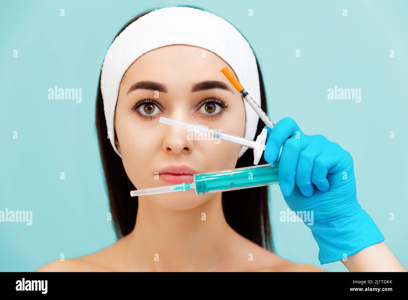 Portrait of a young attractive woman holding three syringes in hands ...