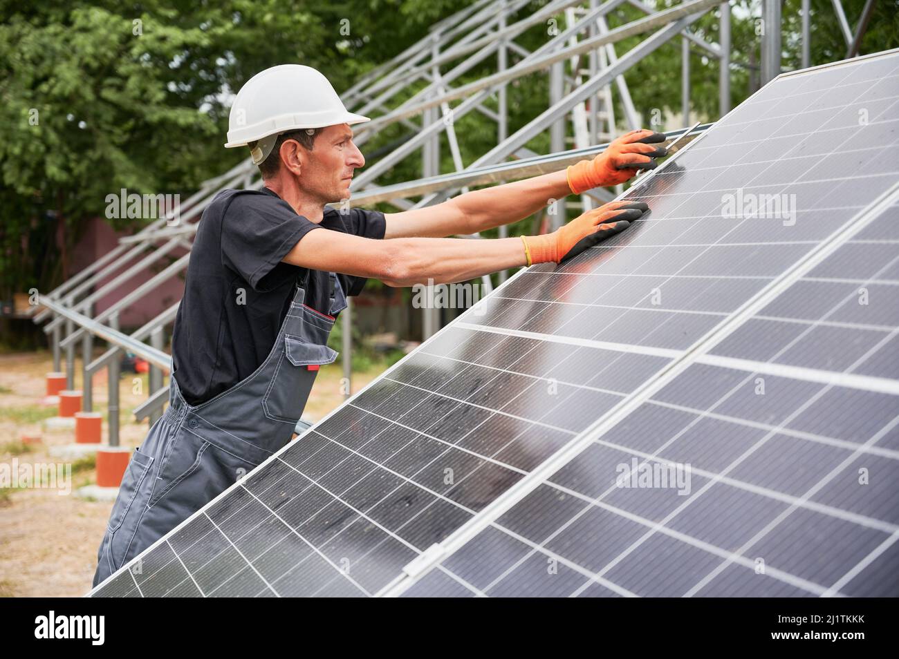Man in safety construction helmet mounting photovoltaic solar panel ...