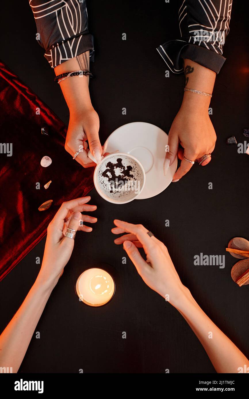 Top down view at female fortune teller reading coffee grounds telling ...