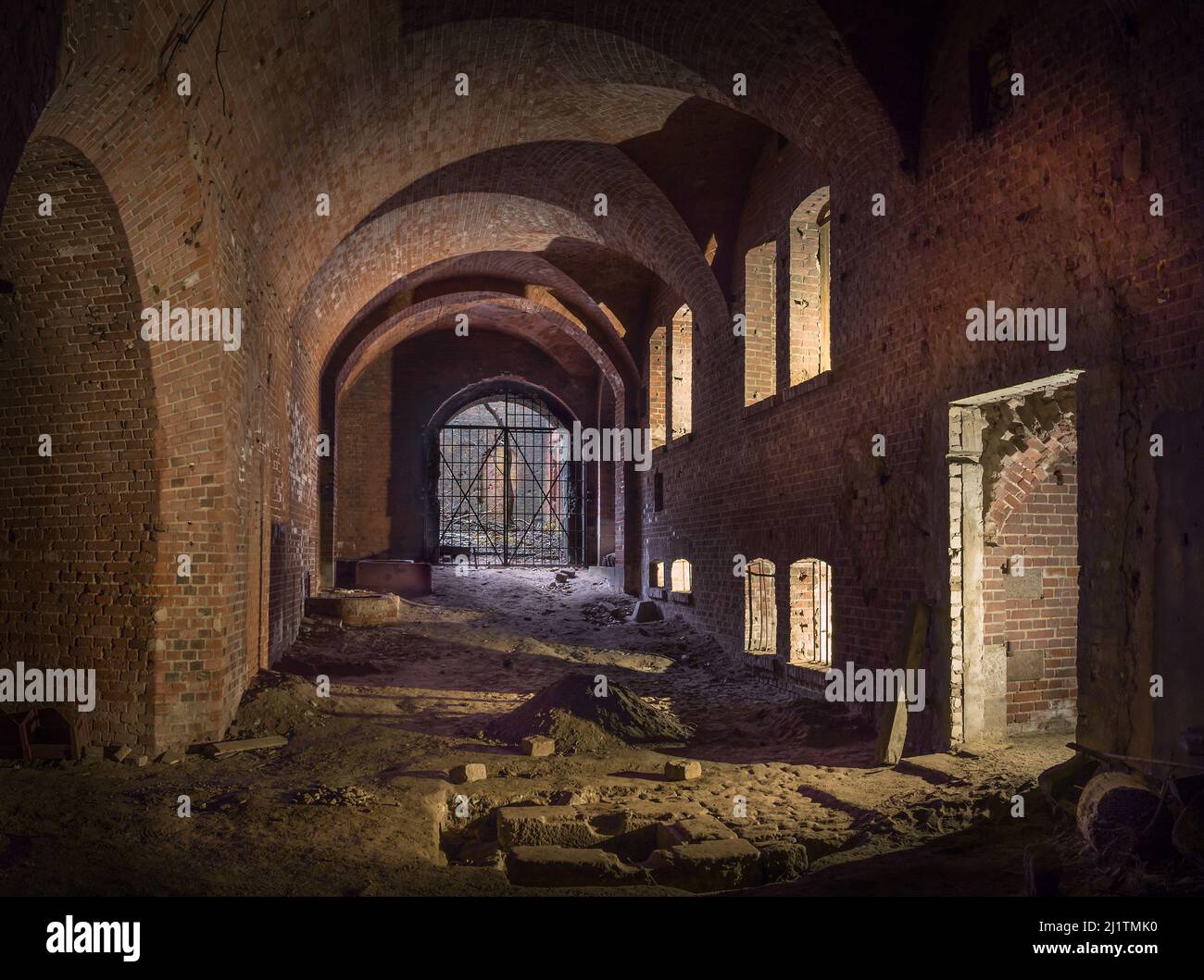 abandoned underground brick corridor with windows illuminated by ...