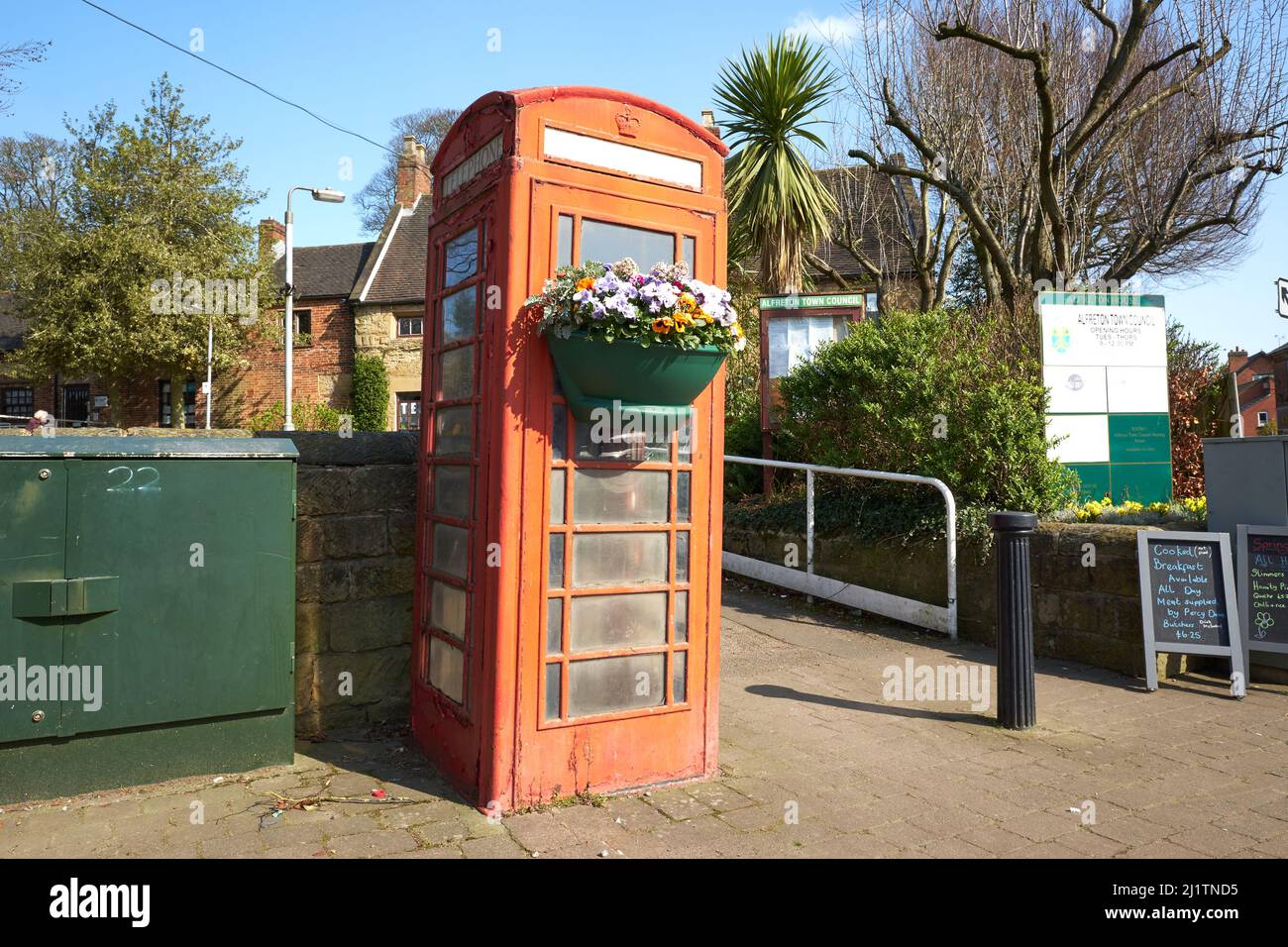 Old red telephone booth with hanging basket Stock Photo - Alamy