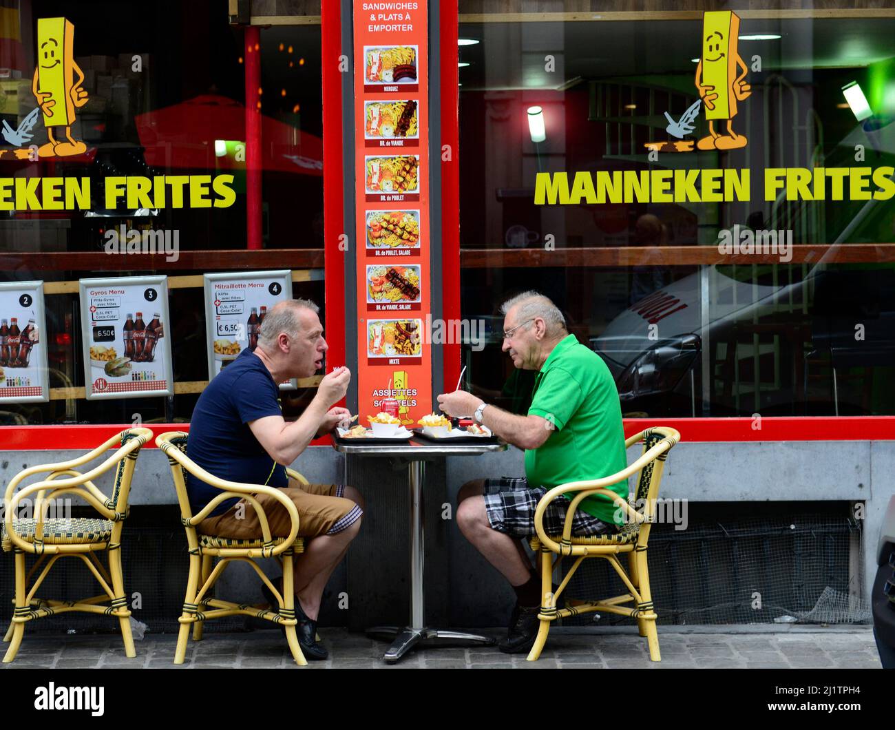 Men enjoying Belgian Frites at the Manneken Frites restaurant in ...