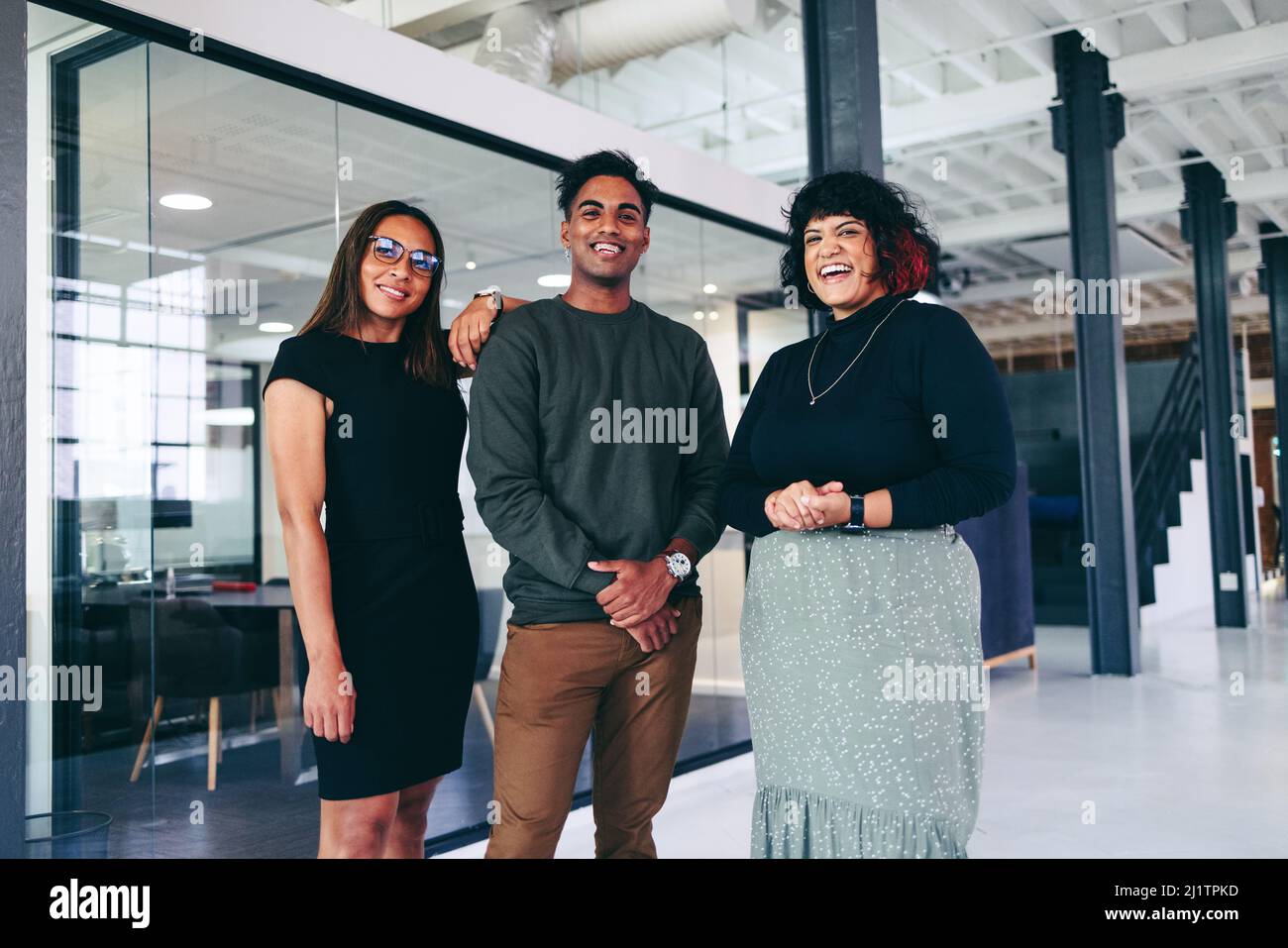 Happy colleagues smiling at the camera while standing together in a ...