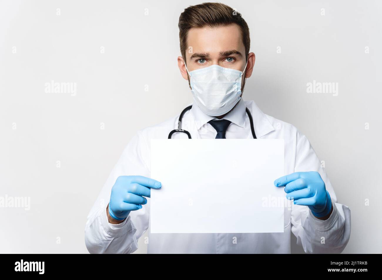 Doctor is holding a sheet of blank white paper Stock Photo - Alamy