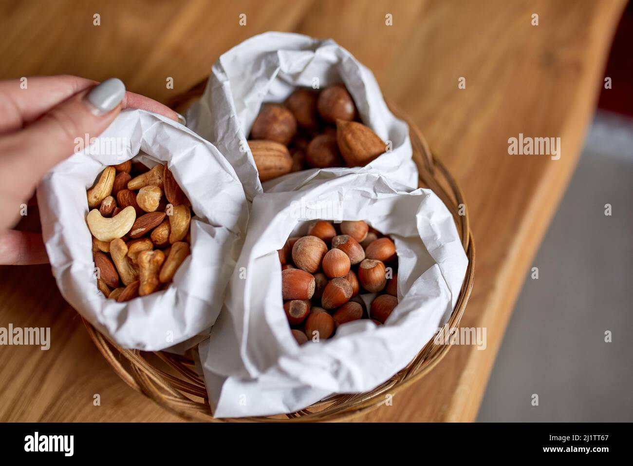 Top view Various sort of nuts on the table in a paper bag on wooden ...