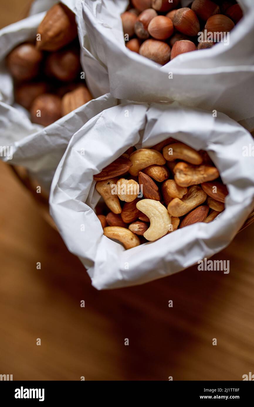 Top view Various sort of nuts on the table in a paper bag on wooden ...