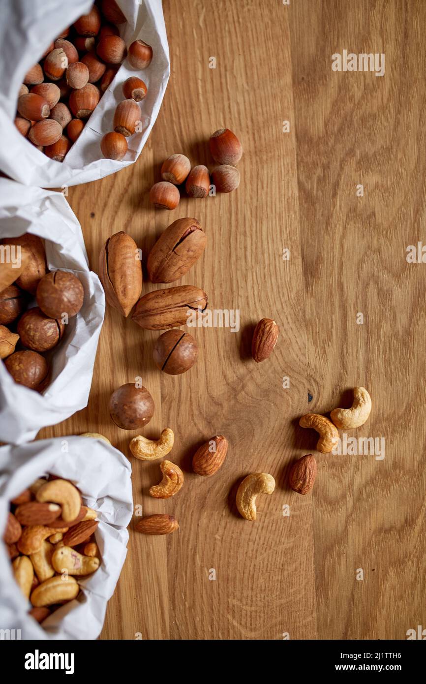Top view Various sort of nuts on the table in a paper bag on wooden ...