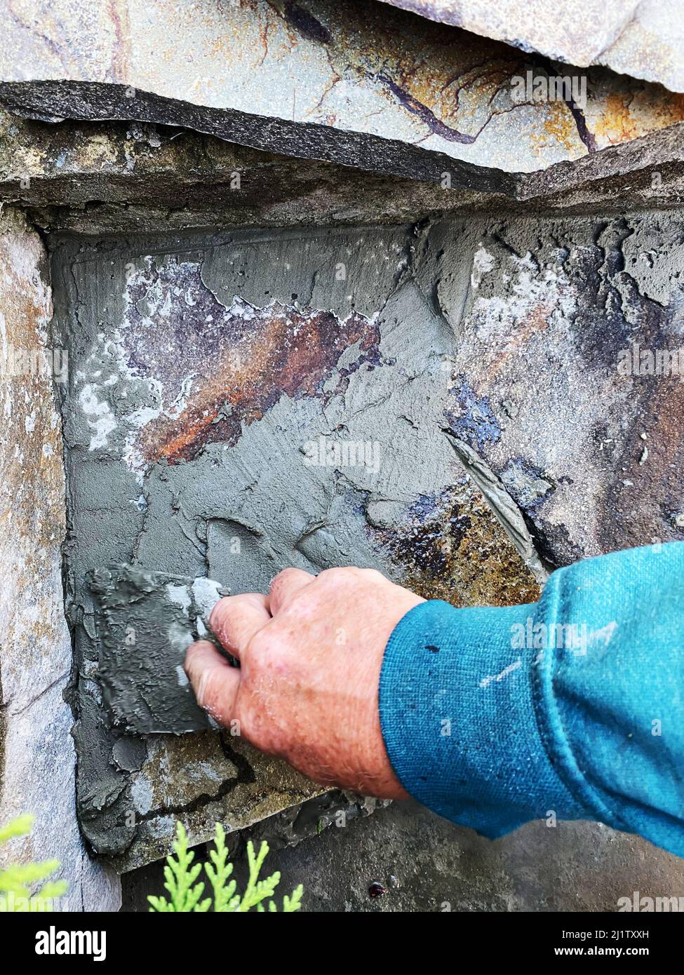 A man lays a stone on the paths on the mortar Stock Photo - Alamy