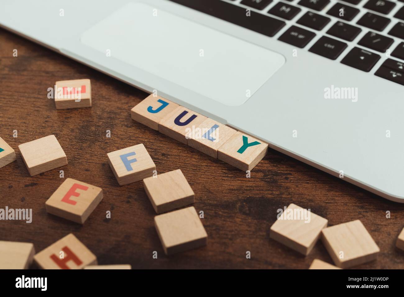 A word JULY made of wooden alphabet letters vocabulary game seasons of ...