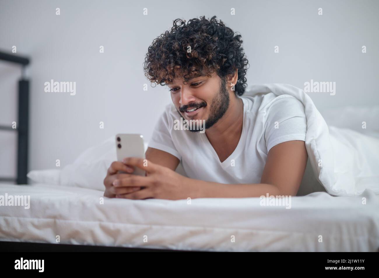 Pleased young man reading a text message Stock Photo - Alamy