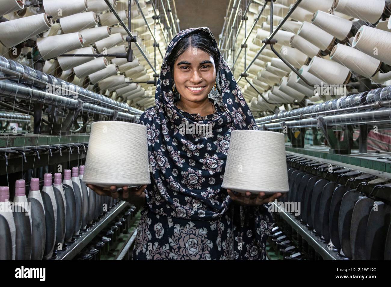 Narayanganj, Dhaka, Bangladesh. 28th Mar, 2022. A worker is showing cones of threads as part of ...