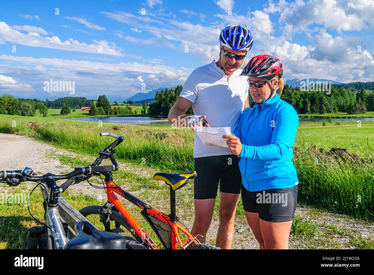 Mountainbikers checking map for the right way Stock Photo - Alamy