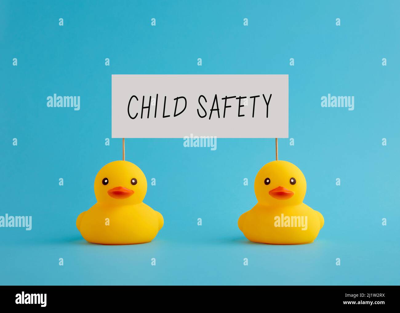 Two rubber ducks carry a signboard with the message child safety Stock ...