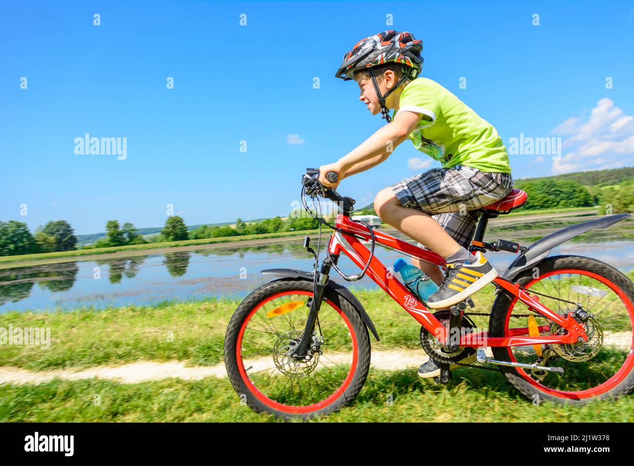 Young boy on the way in nature with his bicycle Stock Photo - Alamy