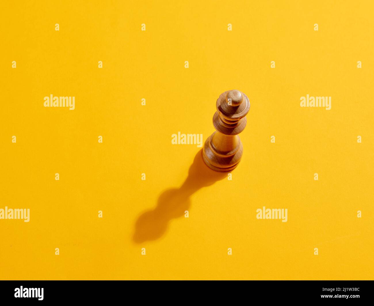 Queen chess piece on yellow background with copy space Stock Photo - Alamy