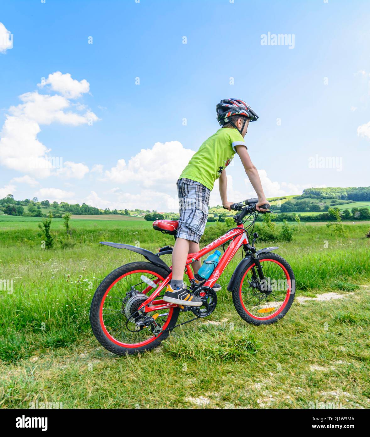 Young boy on the way in nature with his bicycle Stock Photo - Alamy