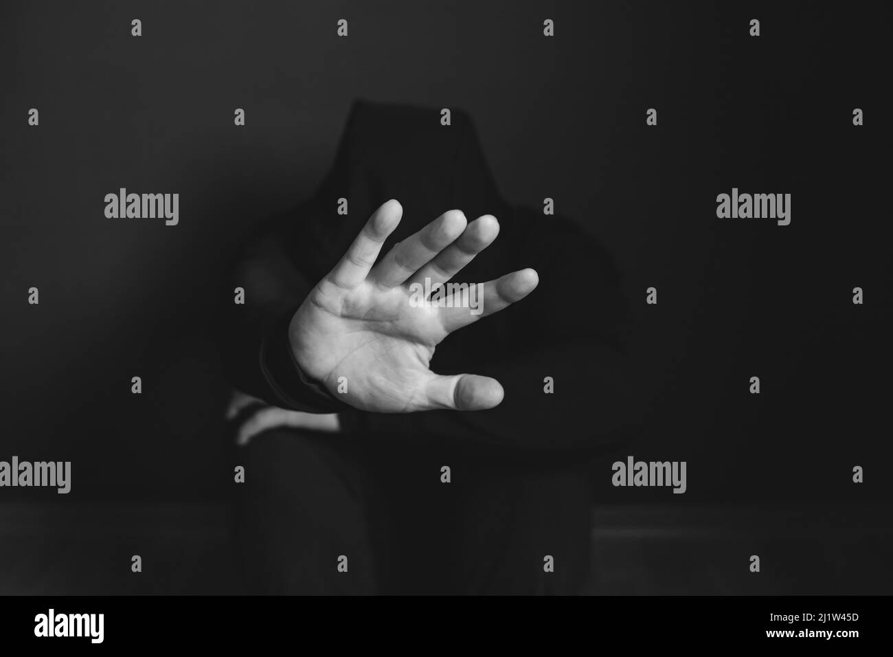 Sad, angry man showing stop sign on dark background. Low key photo ...