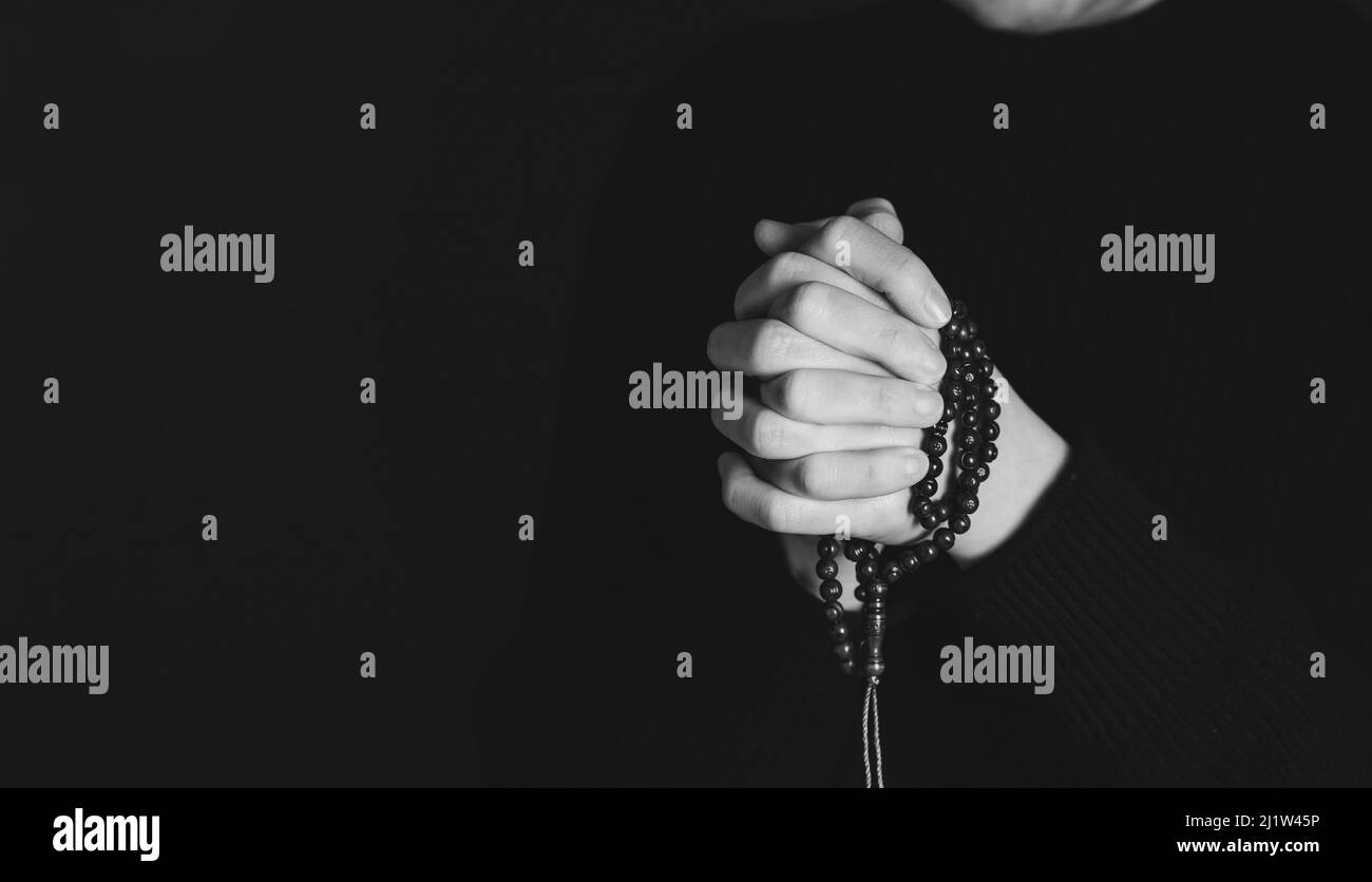 Religious young woman praying to God, on dark background Stock Photo ...