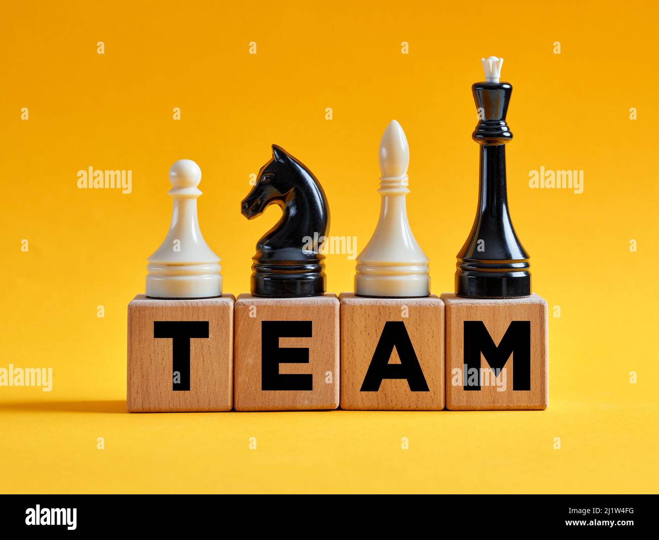 The word team on wooden cubes with different chess pieces. Business ...