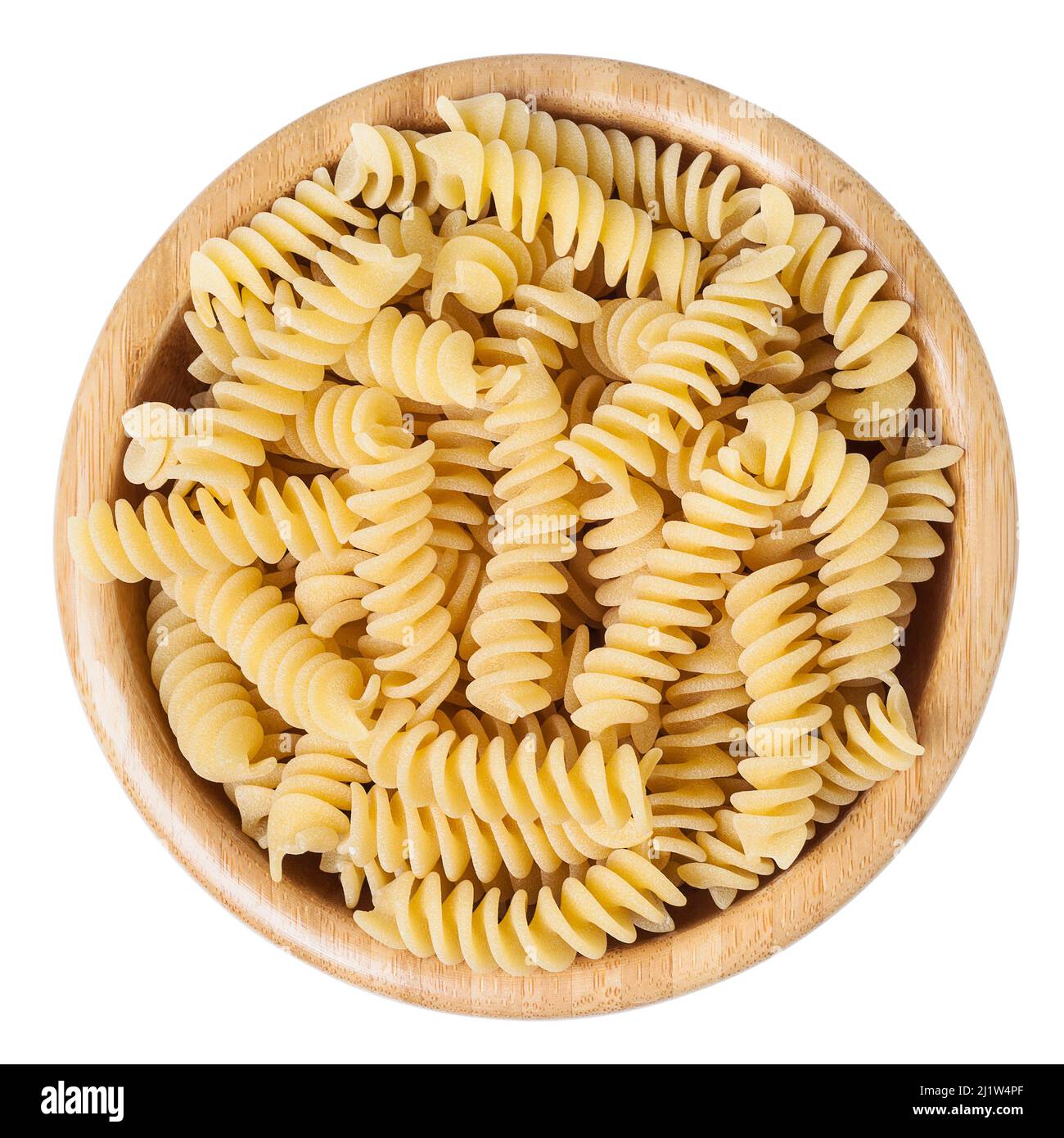 Uncooked fusilli pasta in wooden bowl isolated on white background with ...