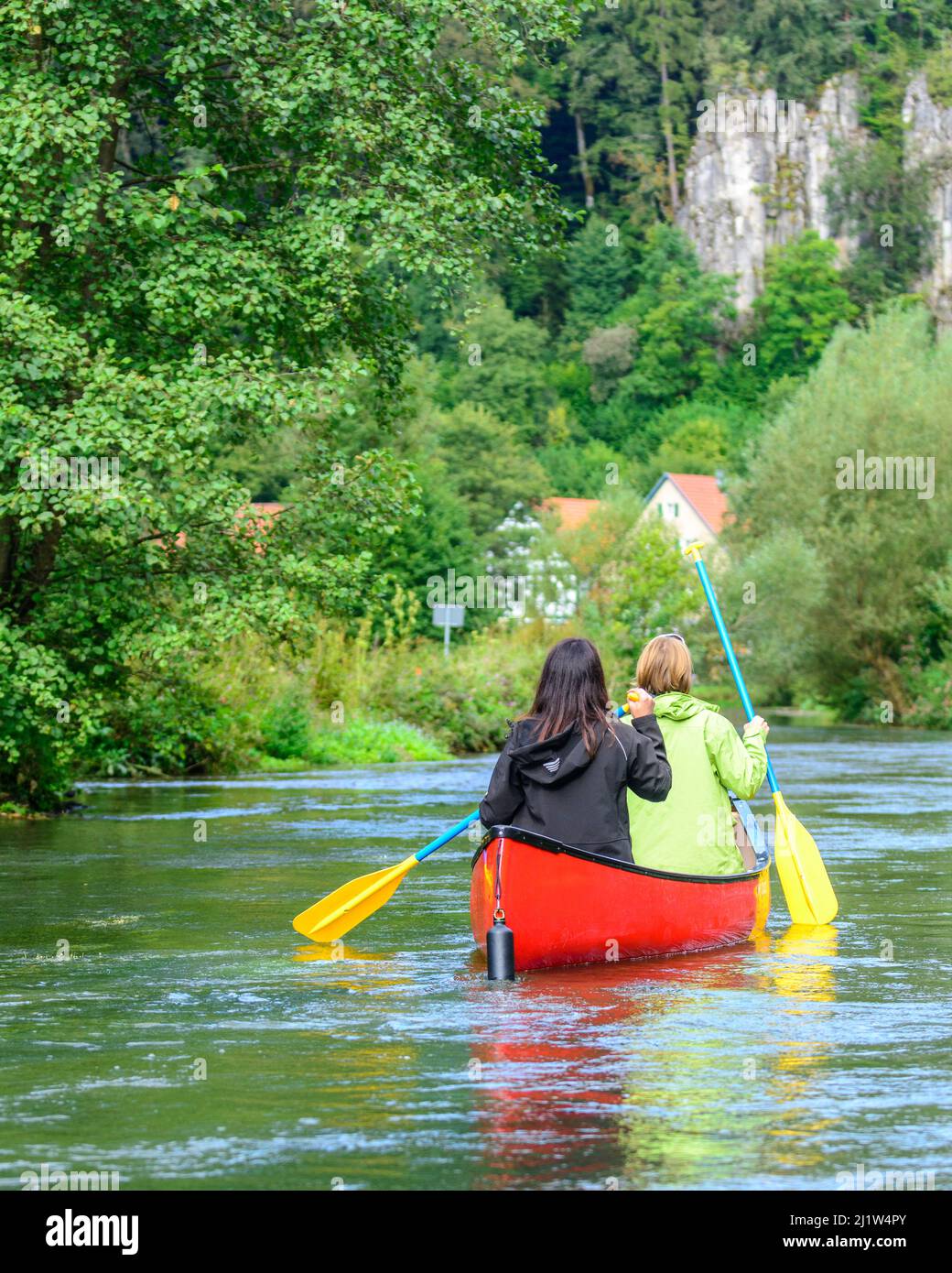 Two women paddling in canoe on small river Stock Photo - Alamy