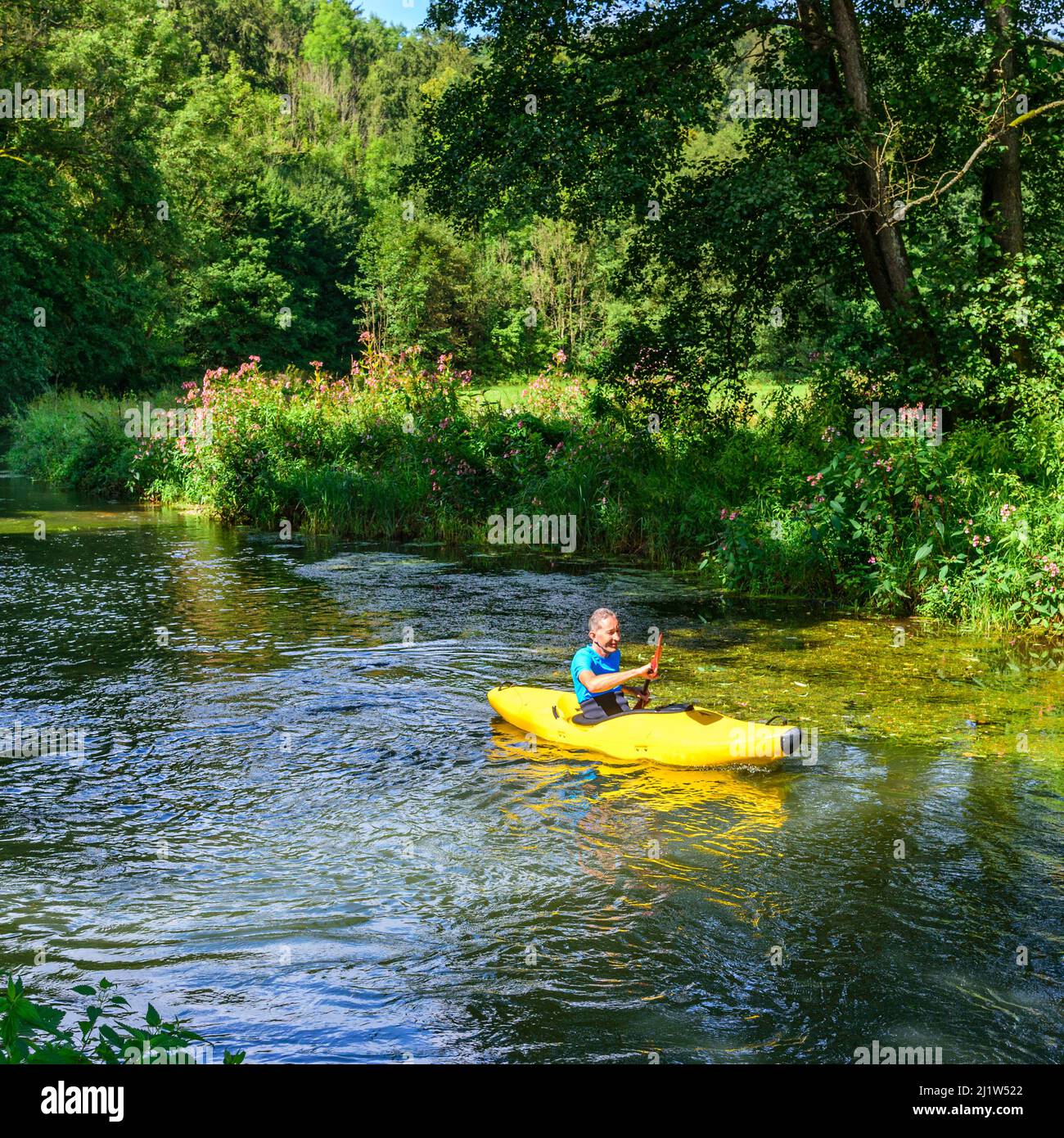 Kayaker paddling down a weir on a river Stock Photo - Alamy