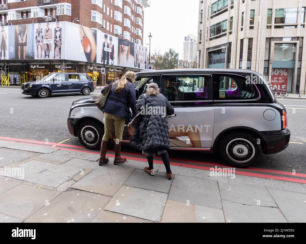 London Taxi; two women getting a london black cab taxi, Knightsbridge ...