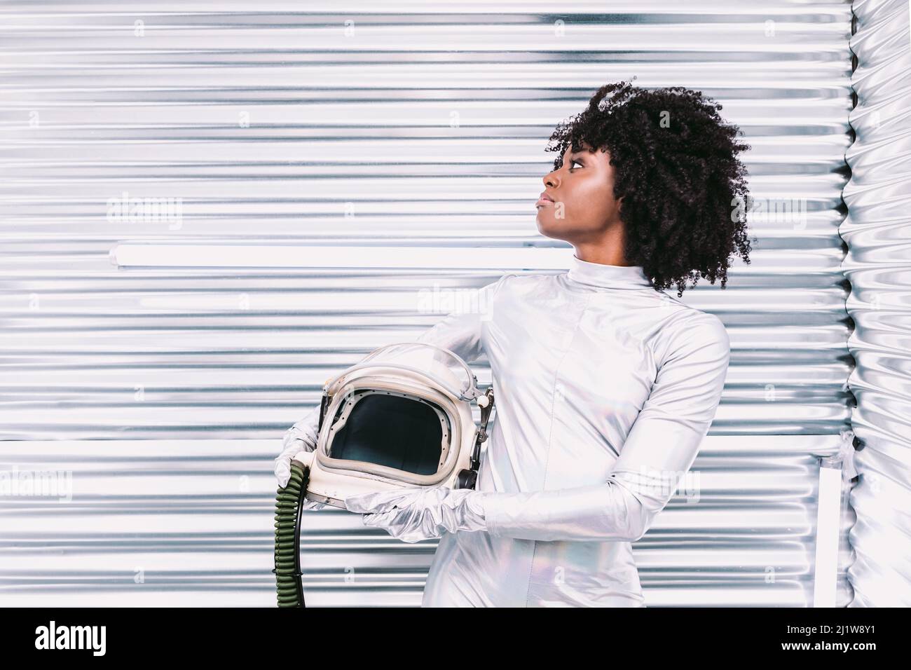 Charming African American female with helmet in white astronaut costume ...