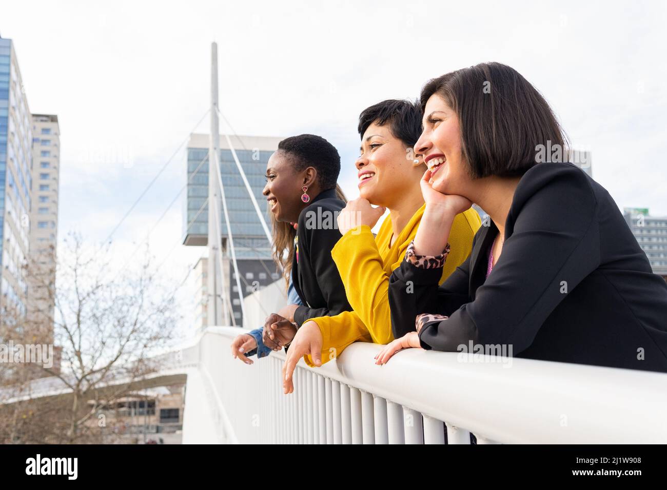 Group of cheerful multiracial female friends leaning looking away ...