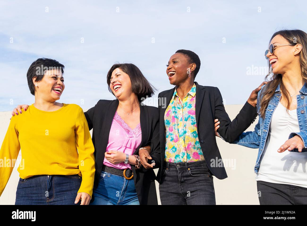 Group of cheerful multiracial female friends chatting and walking ...