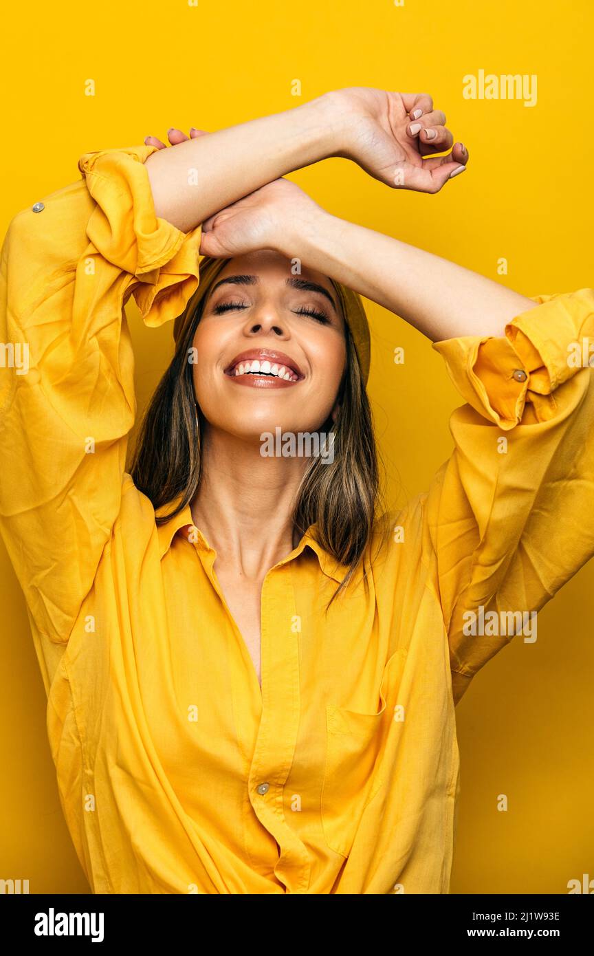charming Hispanic positive female model raising arms while dancing in ...