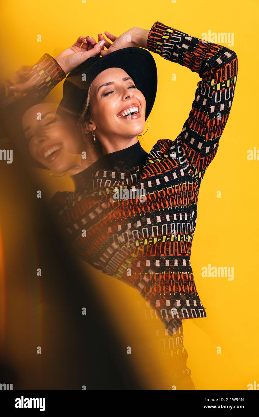 Cheerful African American female singer in headphones with smartphone ...