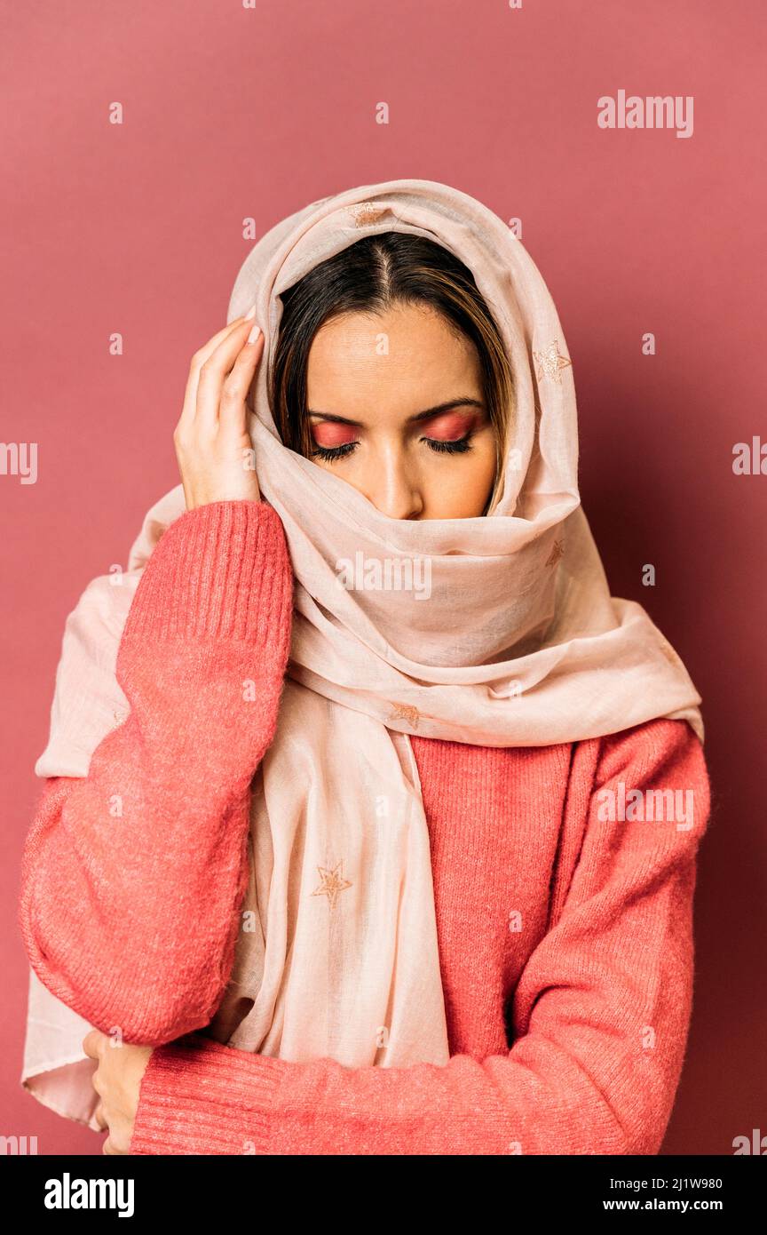 Peaceful arab female with makeup covering face with long light ...