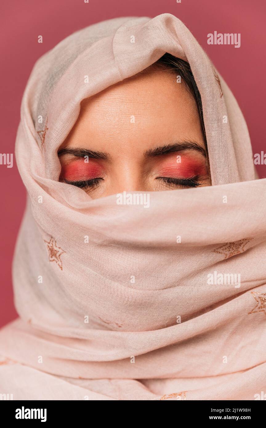 Peaceful arab female with makeup covering face with long light ...