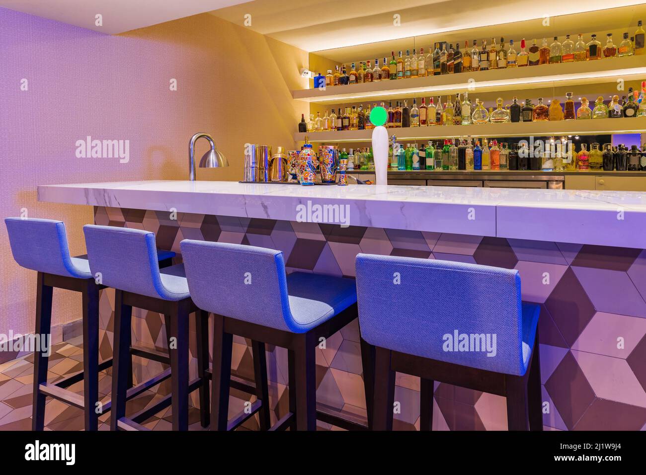 Interior of stylish bar with stools at counter with beer tap and ...