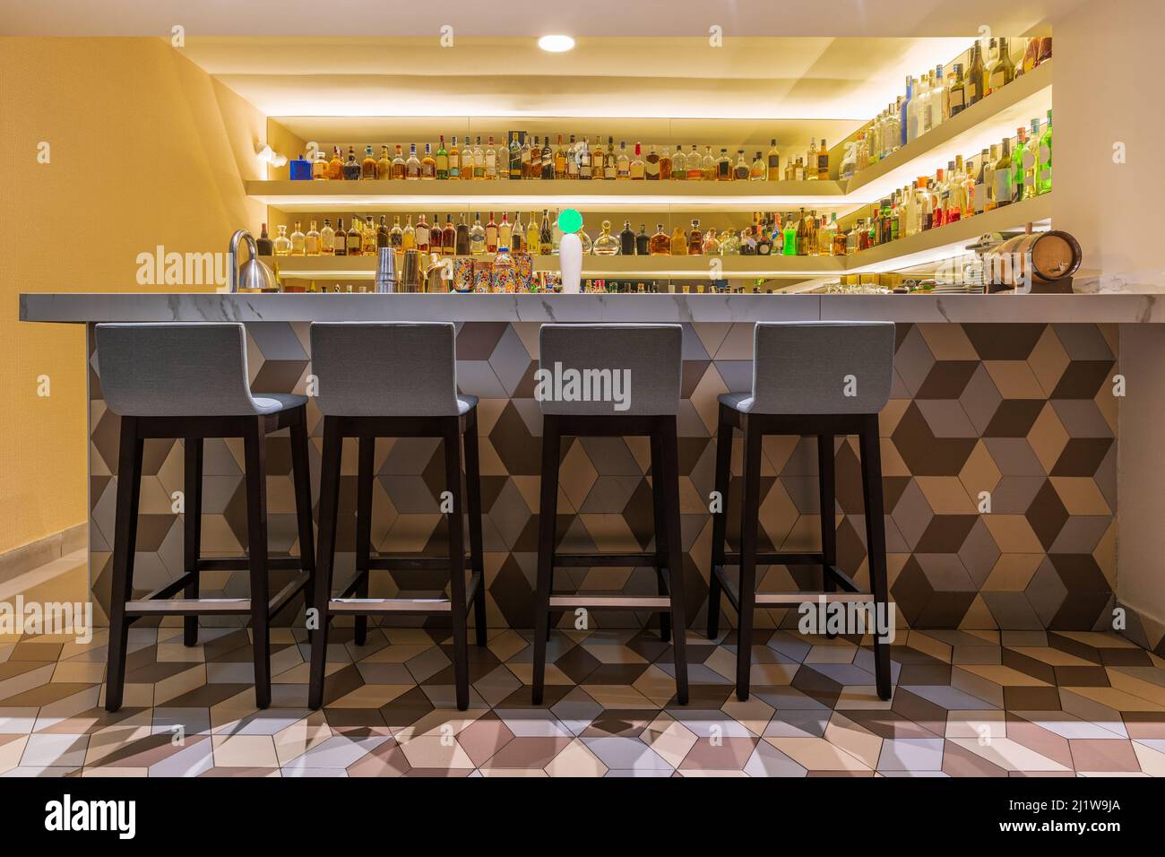 Interior of stylish bar with stools at counter with beer tap and ...