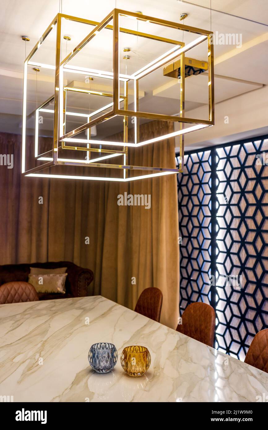 Modern luminous square shaped golden lamp hanging on ceiling and ...